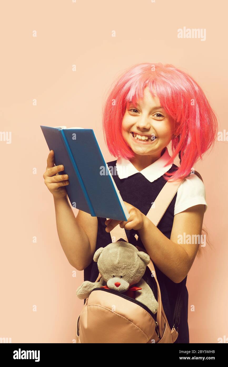 Schoolgirl with pink wig isolated on light pink background. Childhood ...