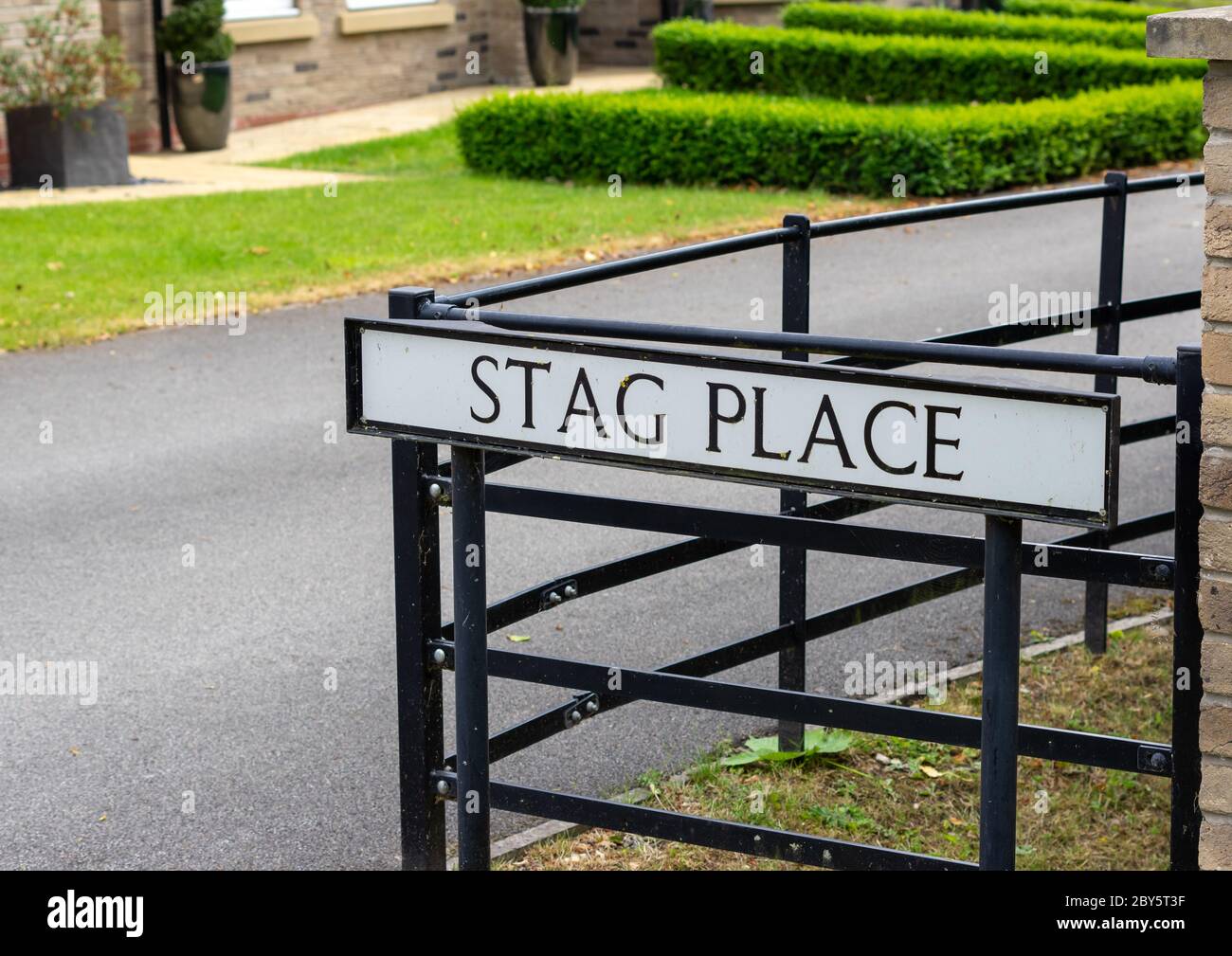 A UK street sign for a street called Stag Place mounted on poles, black ...