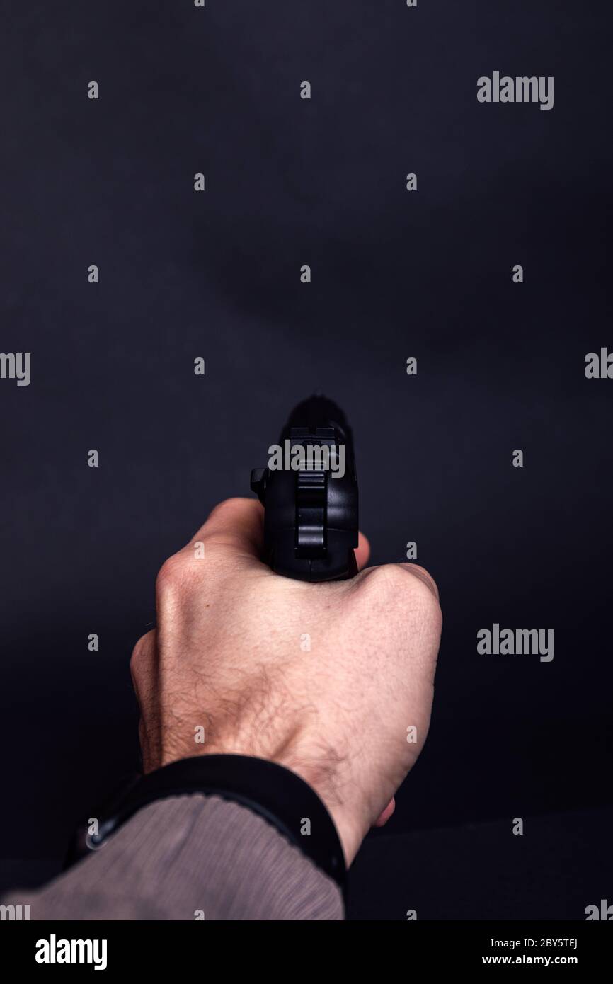 Male hand with gun isolated on black background. Man with a gun ready ...