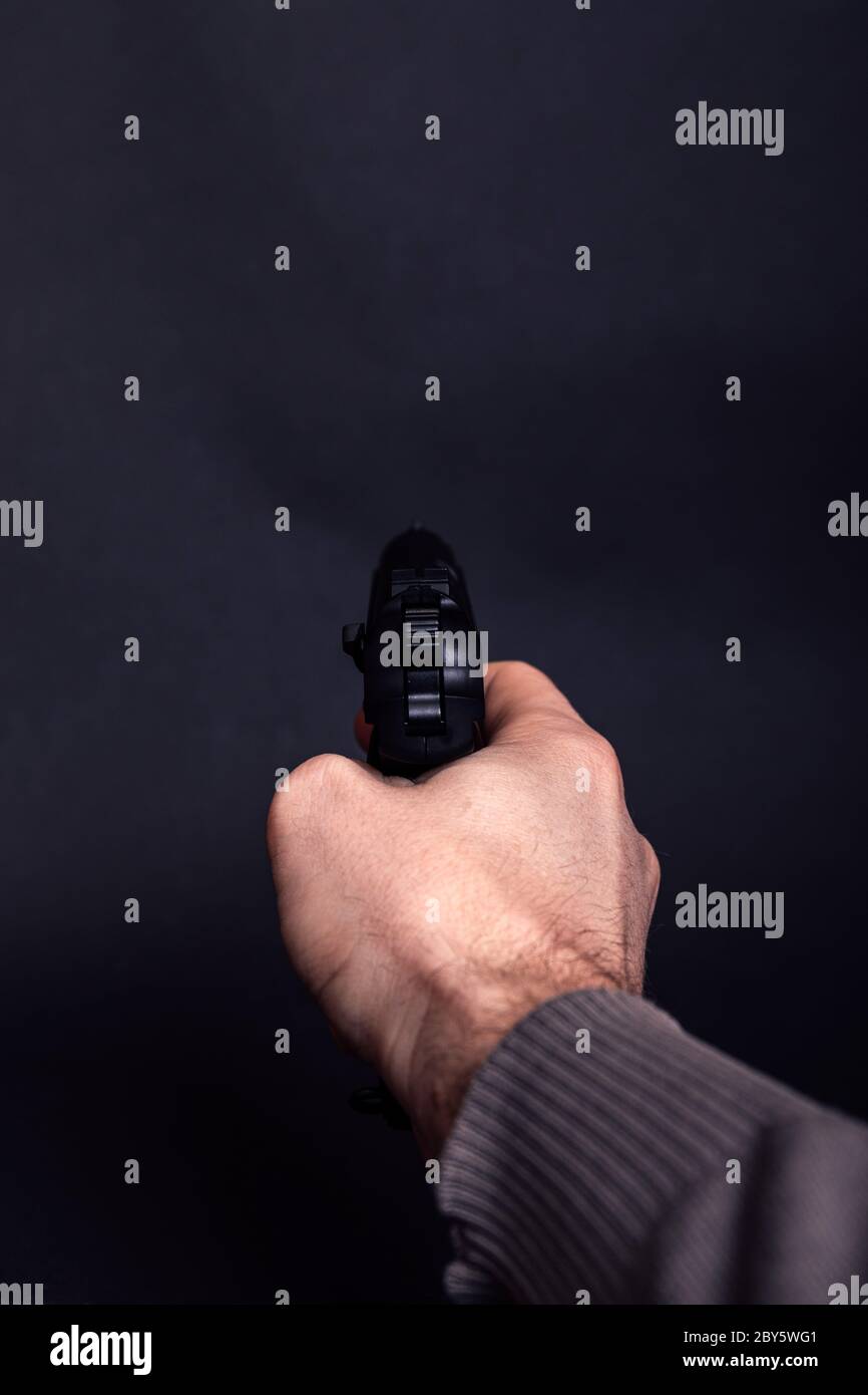 Male hand with gun isolated on black background. Man with a gun ready ...