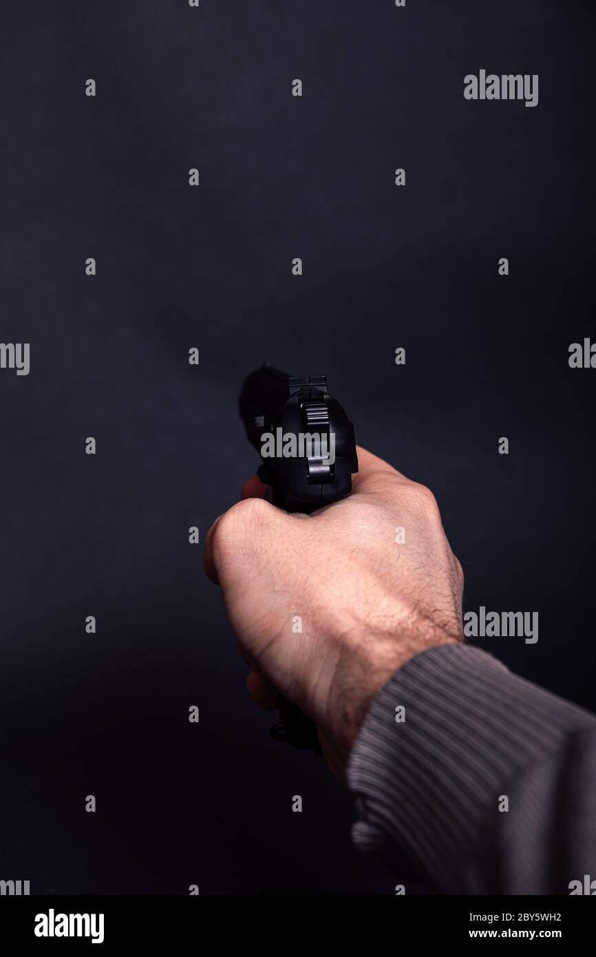 Male hand with gun isolated on black background. Man with a gun ready ...