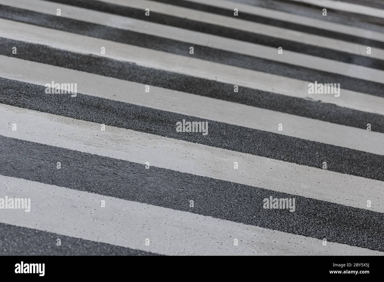 High angle detail view of pedestrian zebra crossing on wet street ...
