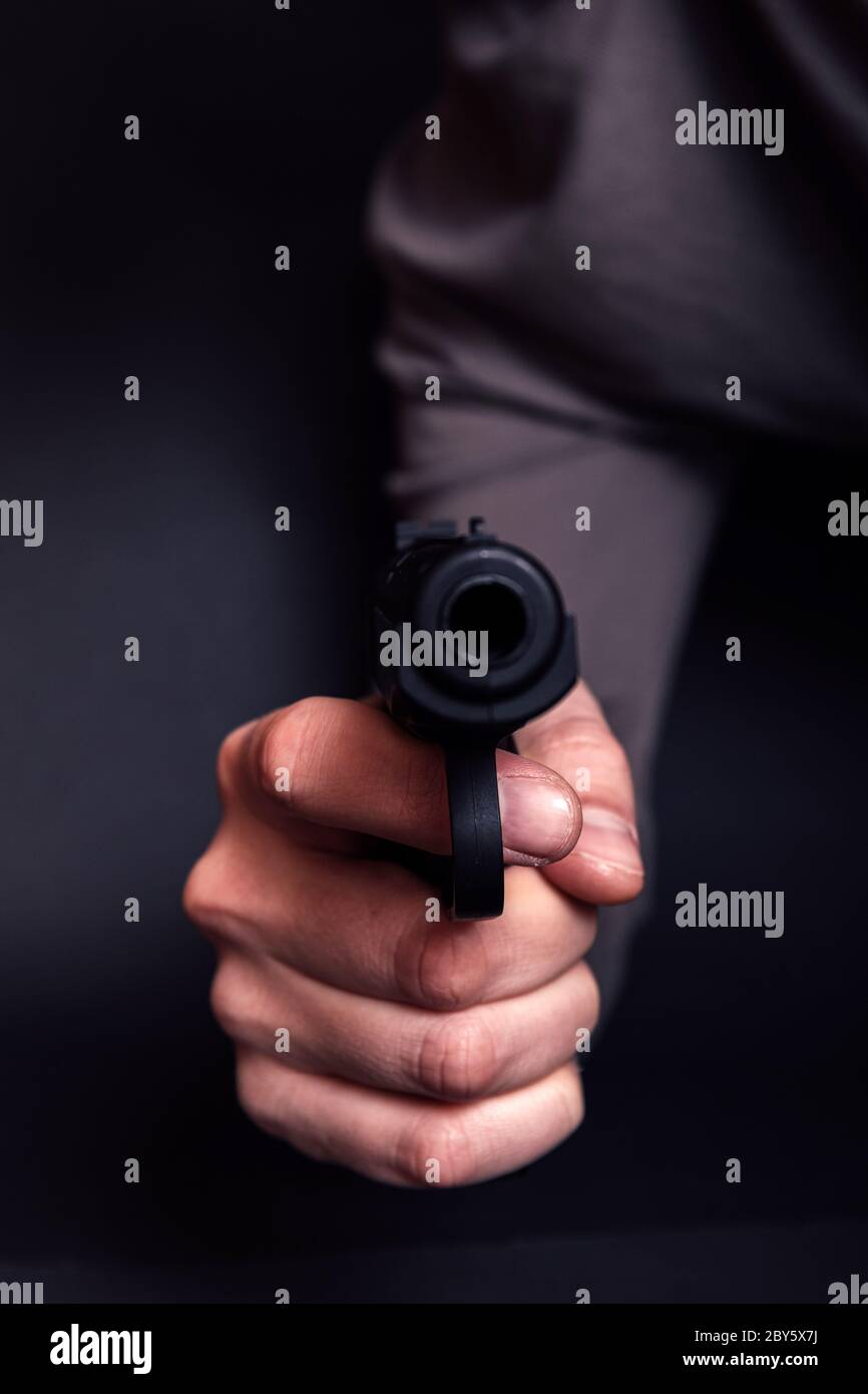 Male hand with gun isolated on black background. Man with a gun ready ...