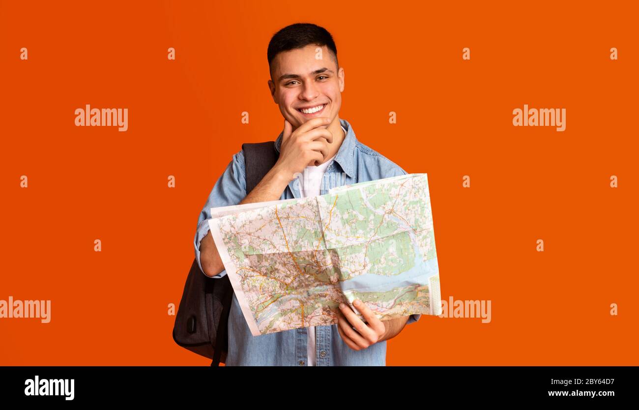 Positive guy making sightseeings, using city map Stock Photo - Alamy