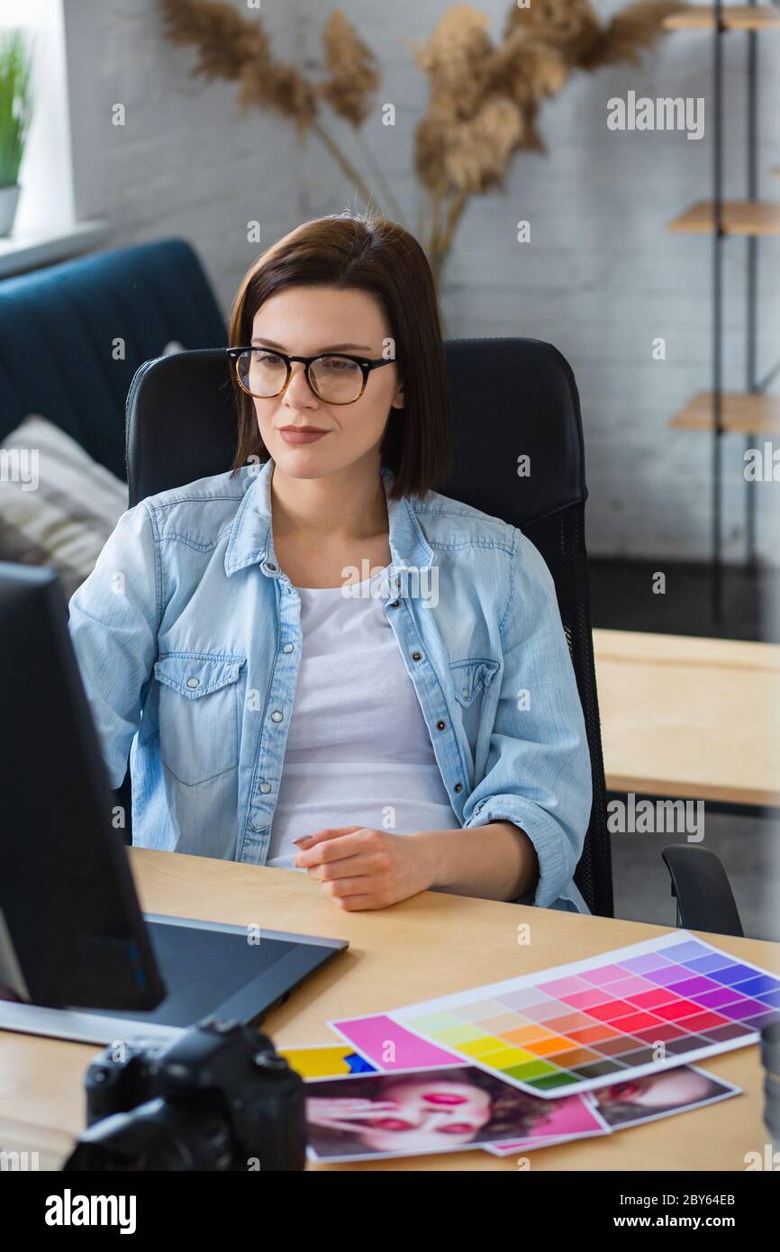 Portrait of graphic designer working in office with laptop,monitor ...