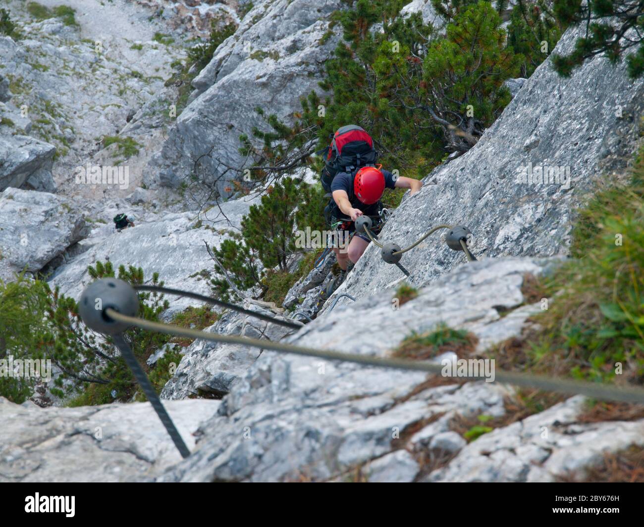 Man climbing vertical wall on via ferrata, view from above Stock Photo ...
