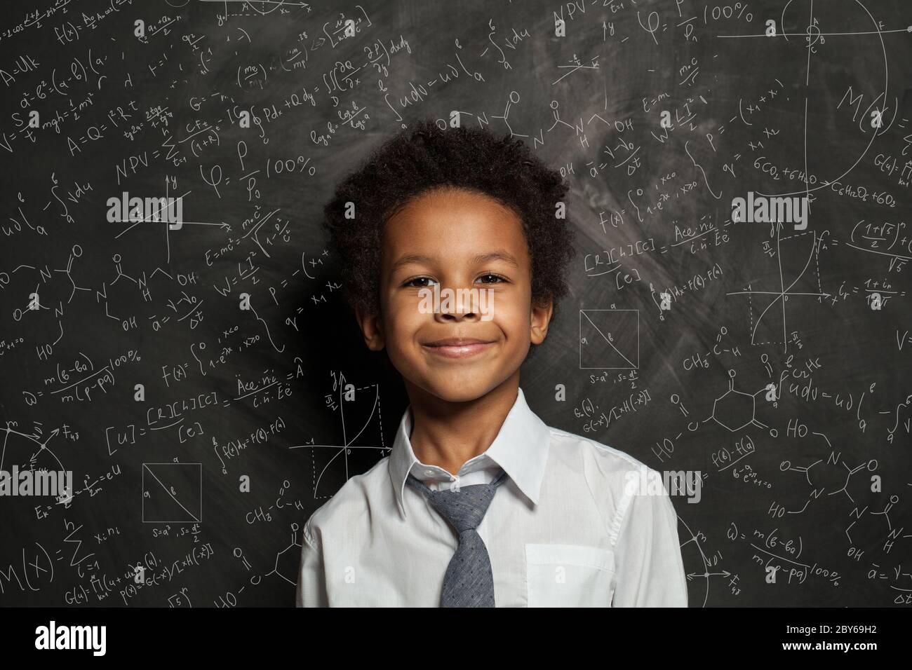 Happy smart black child student on blackboard background with science ...