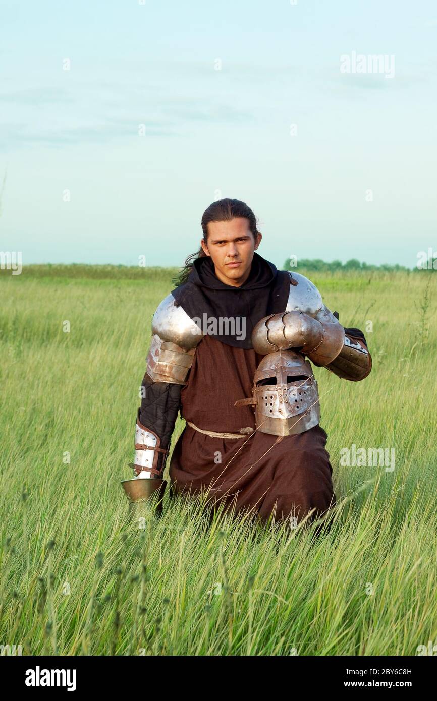 Medieval knight in the field with an helmet Stock Photo - Alamy