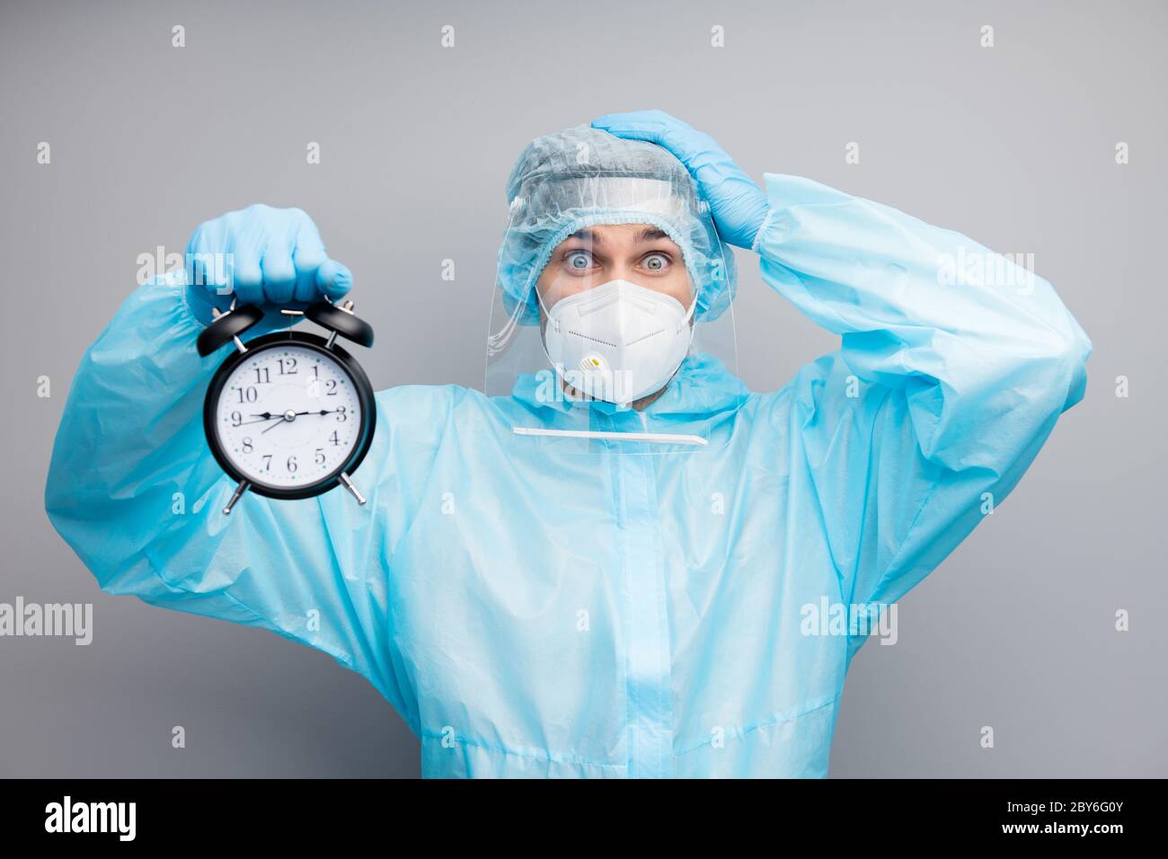 Photo of guy doc virology center eyes full fear hold alarm clock ...