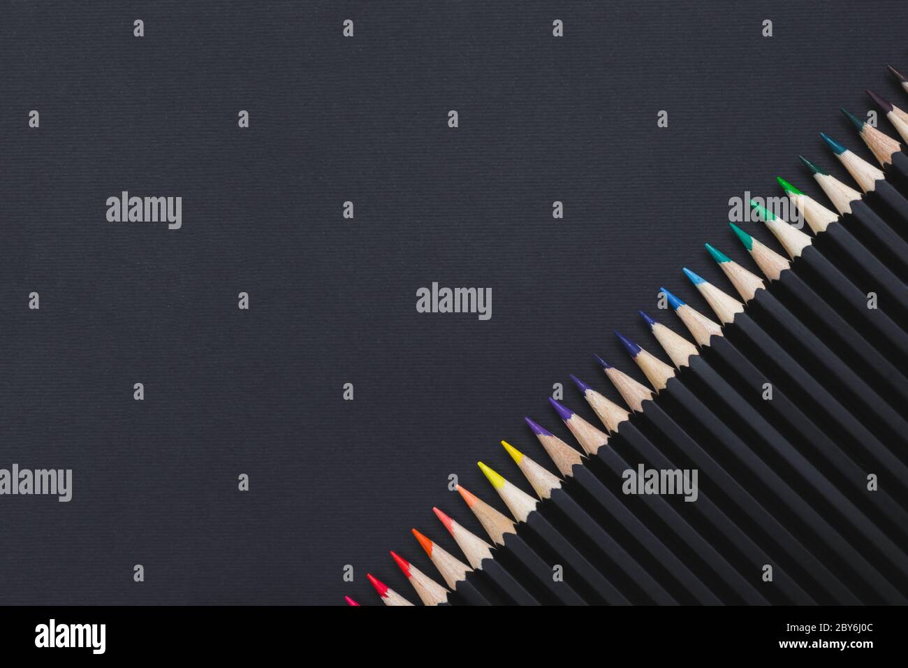 Colored pencil set arranged in diagonal on black background. Stationery ...