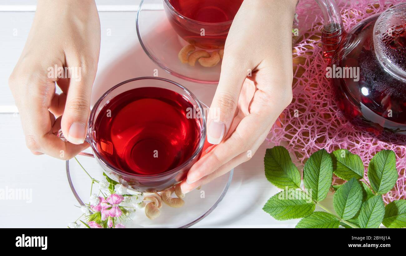 A woman holds a Cup of tea. Red tea, hibiscus, karkade, Rooibos ...