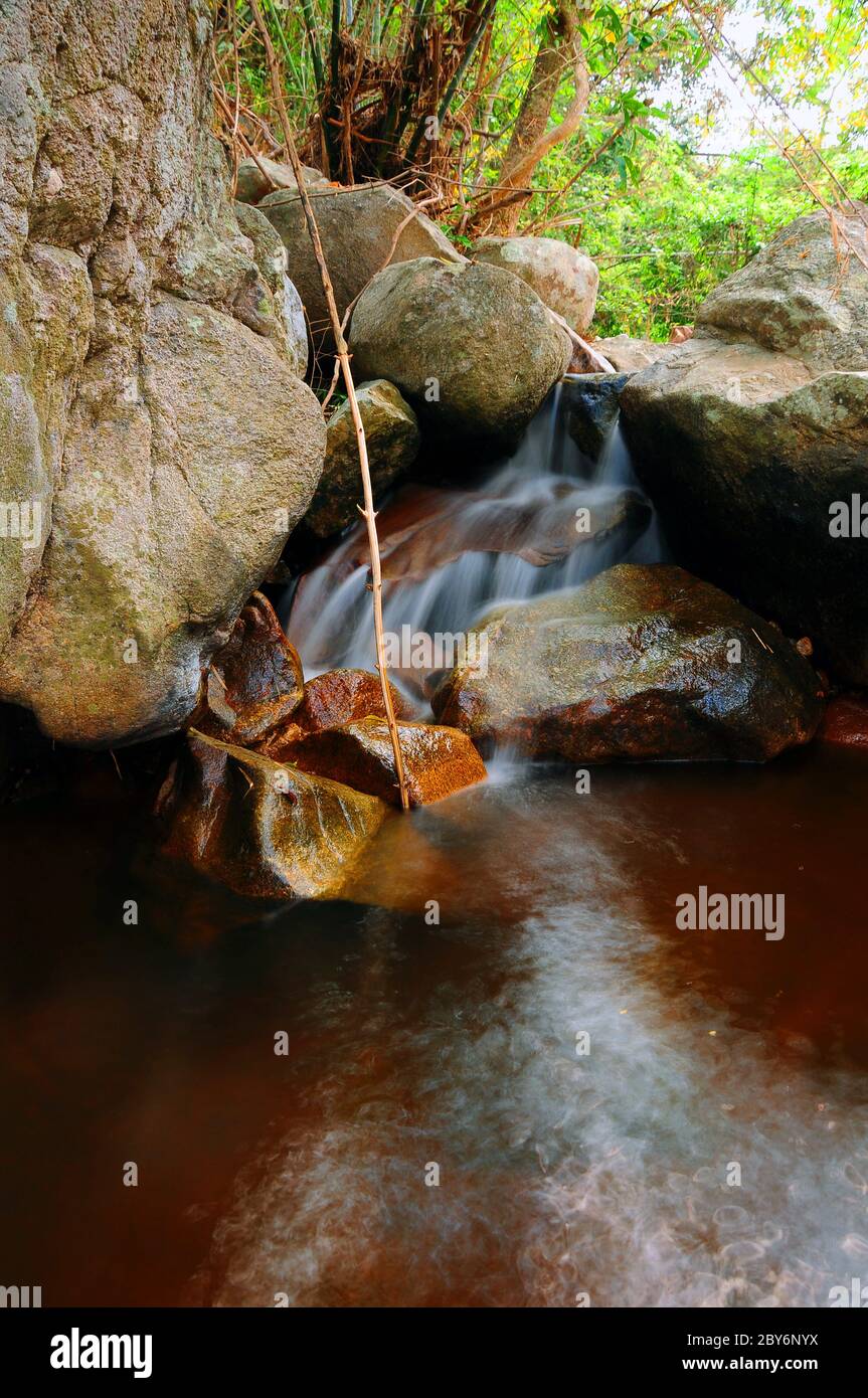 Waterfall with water flowing around Stock Photo - Alamy
