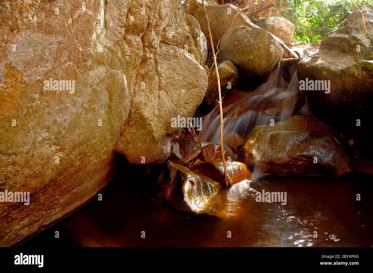 Waterfall with water flowing around Stock Photo - Alamy