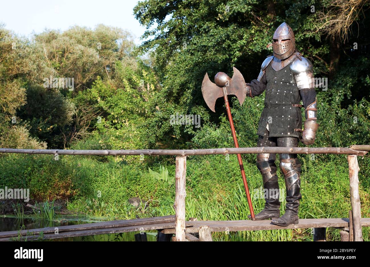Medieval knight in the field with an axe Stock Photo - Alamy