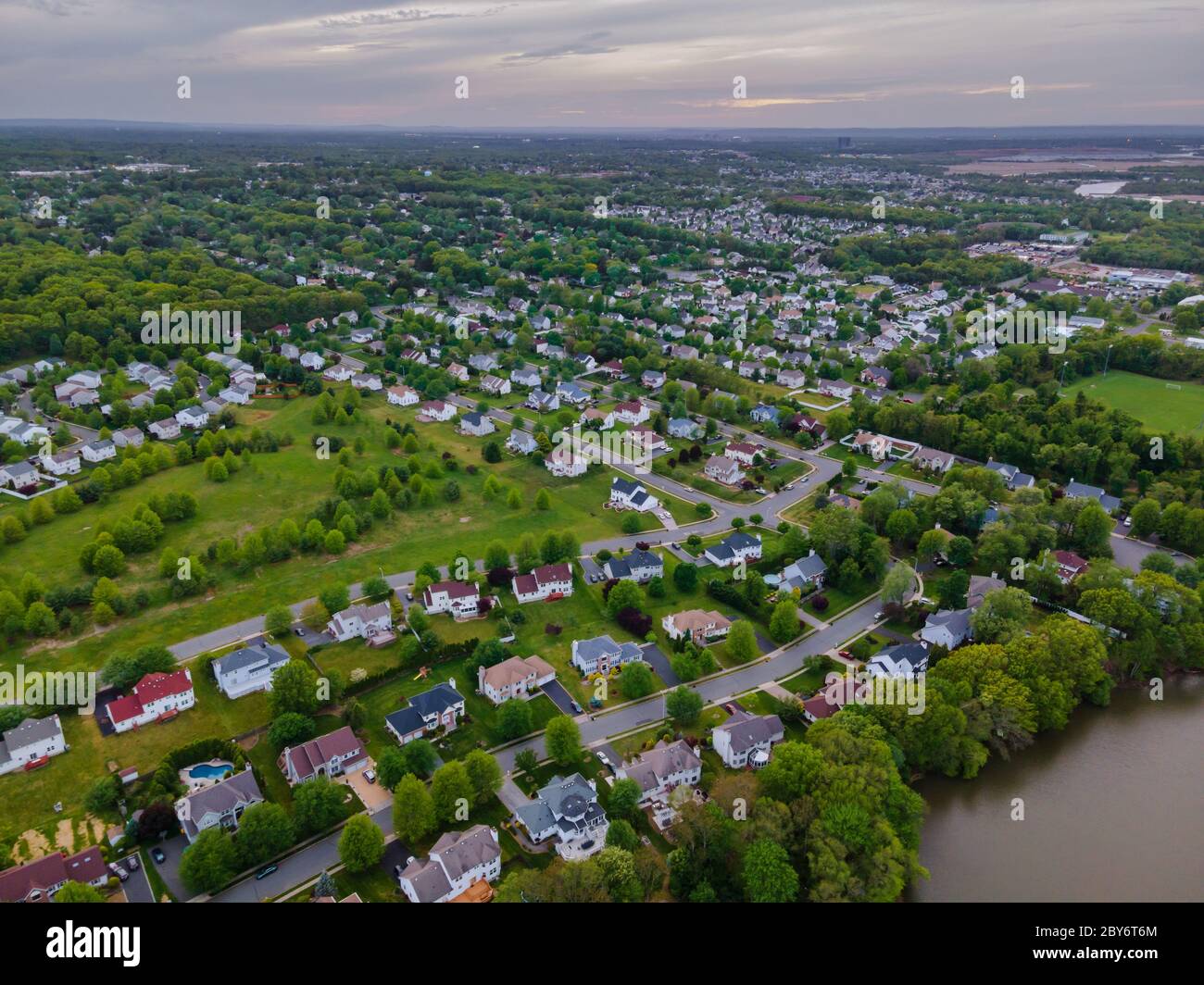 Aerial view over suburban residential district roofs homes and roads NJ ...