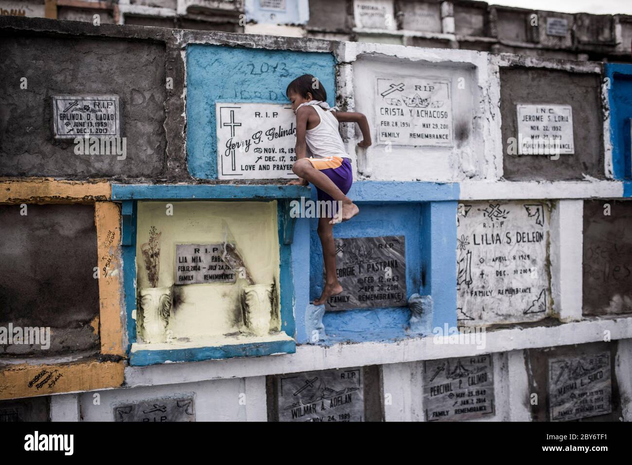 A child plays climbing some graves at Navotas cemetery in Manila ...