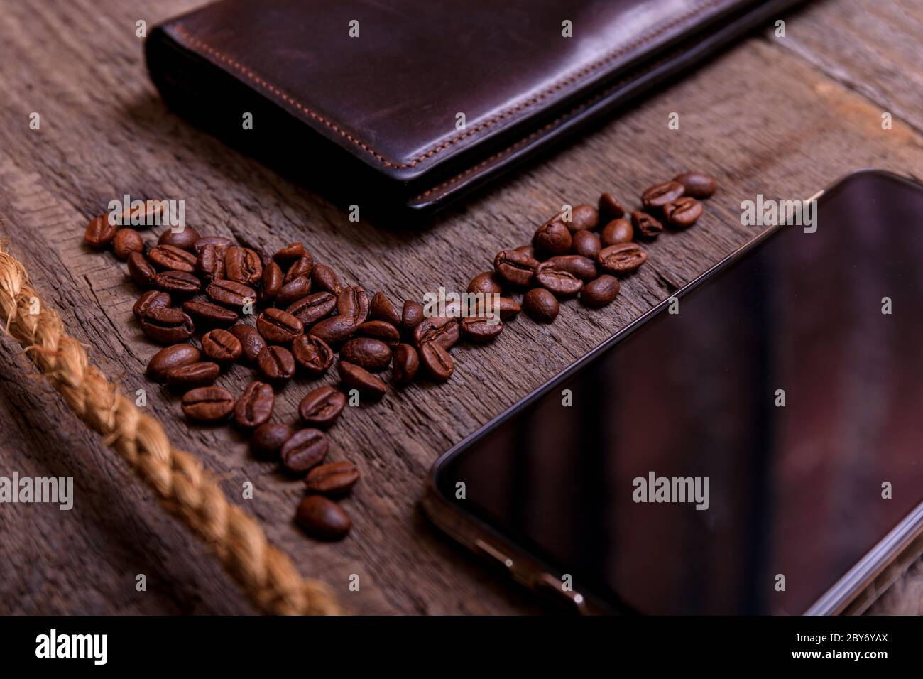 Still life photography of brown leather wallet, coffee beans, mobil ...