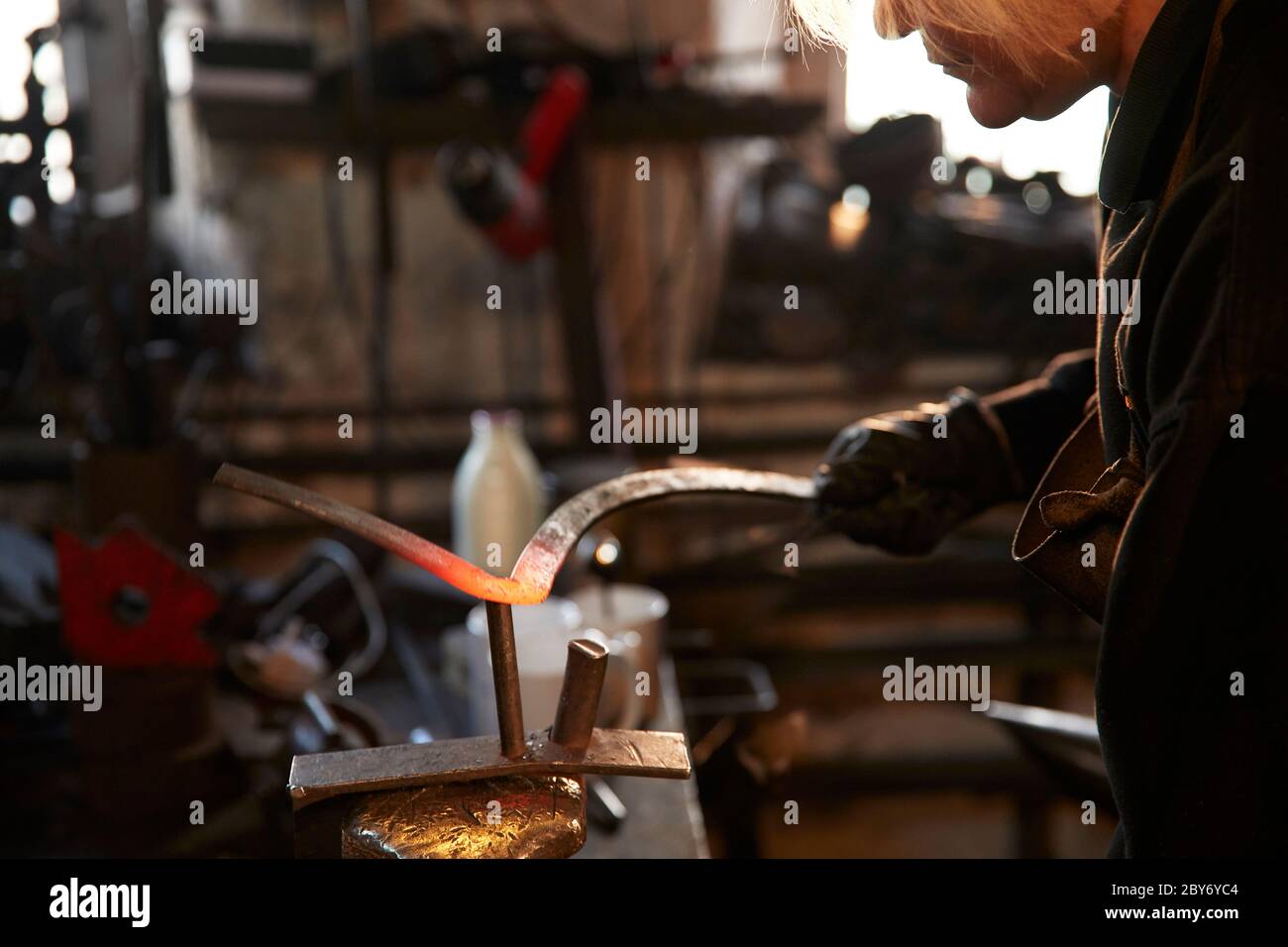 Female blacksmith shaping steel in workshop Stock Photo - Alamy