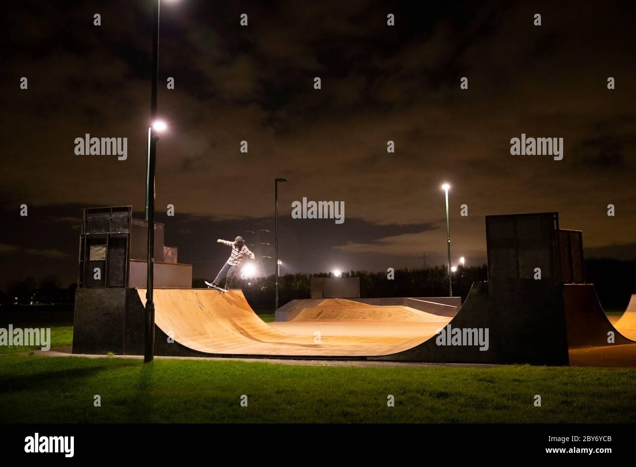 Young man skateboarding on skate park ramp at night Stock Photo - Alamy