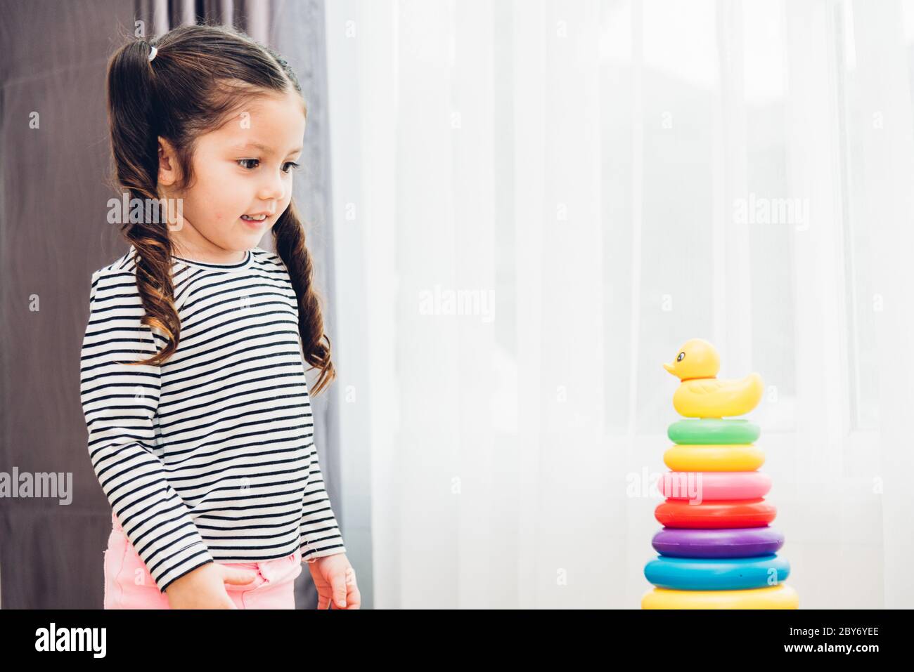 Beautiful kid girl play loop toy education at home before preschool ...