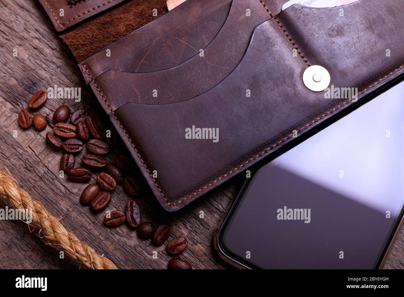 Still life photography of brown leather wallet, coffee beans, mobil ...