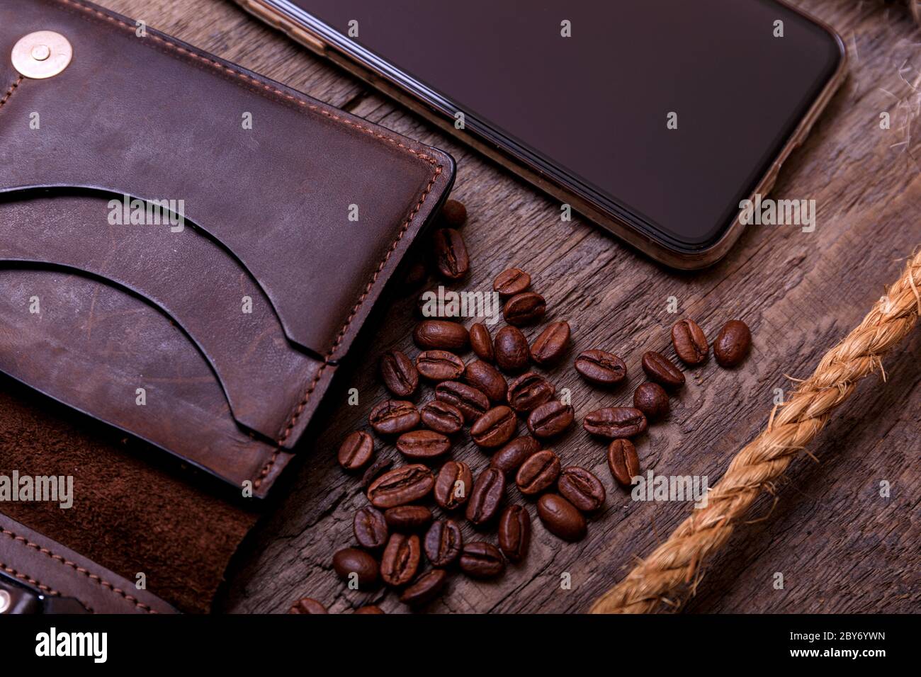 Still life photography of brown leather wallet, coffee beans, mobil ...