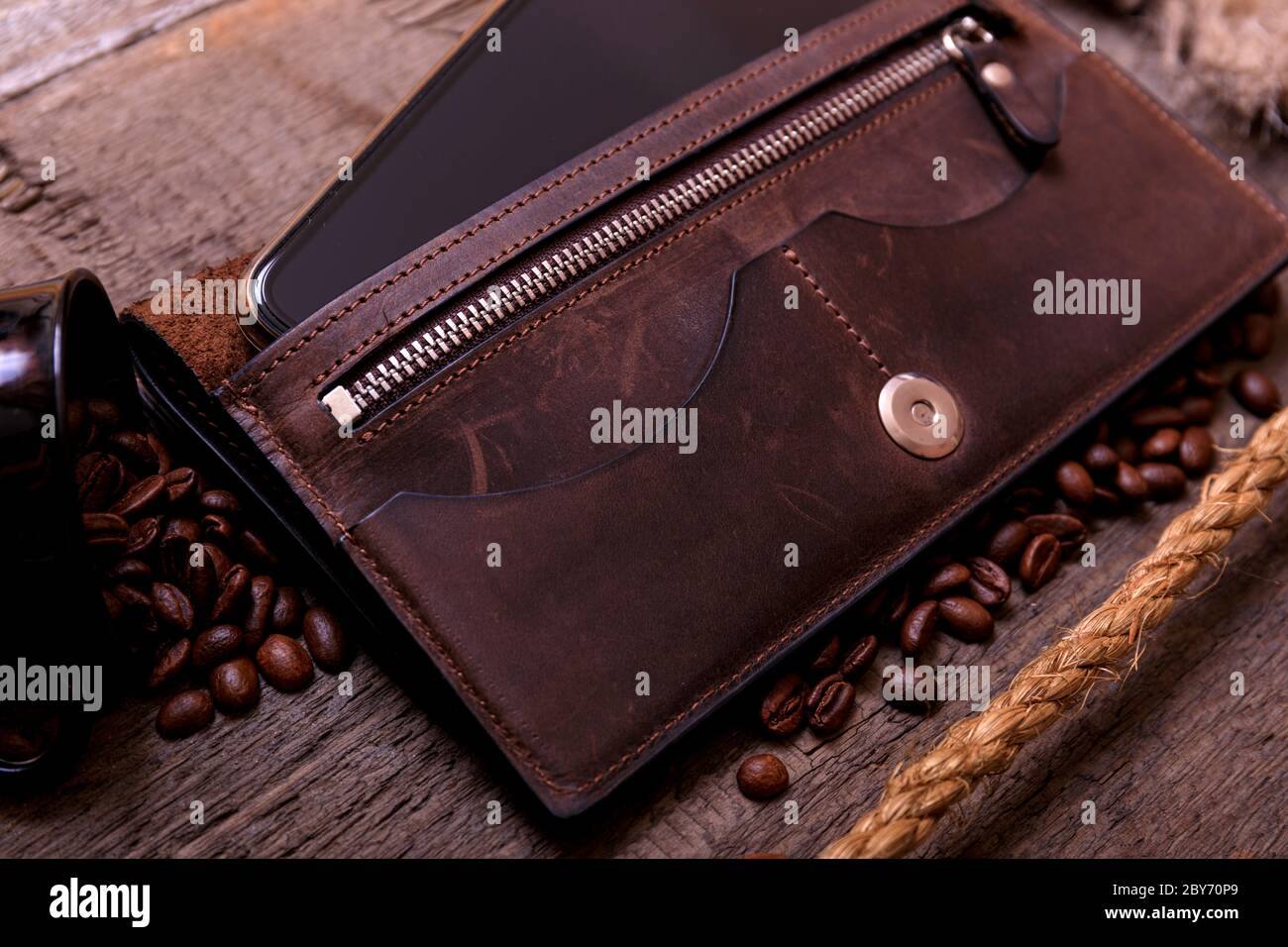 Still life photography of brown leather wallet, coffee beans, mobil ...