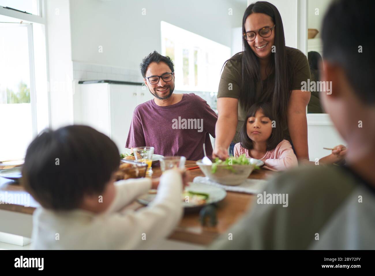 Happy family eating lunch at dining table Stock Photo - Alamy