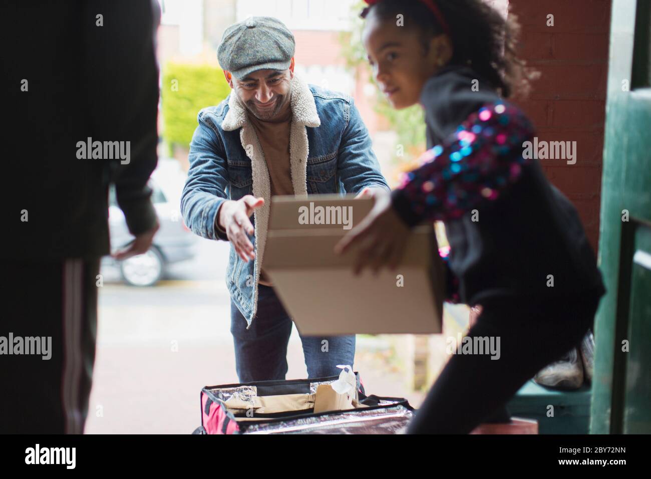 Girl receiving pizza delivery from delivery man at front door Stock ...