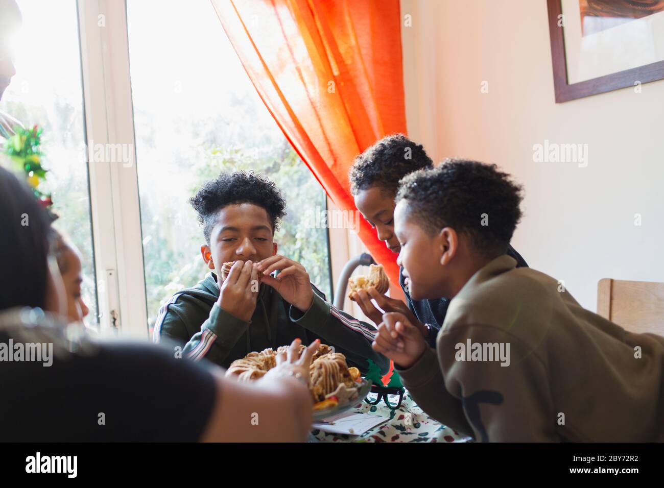 Hungry family eating Christmas cake at table Stock Photo - Alamy