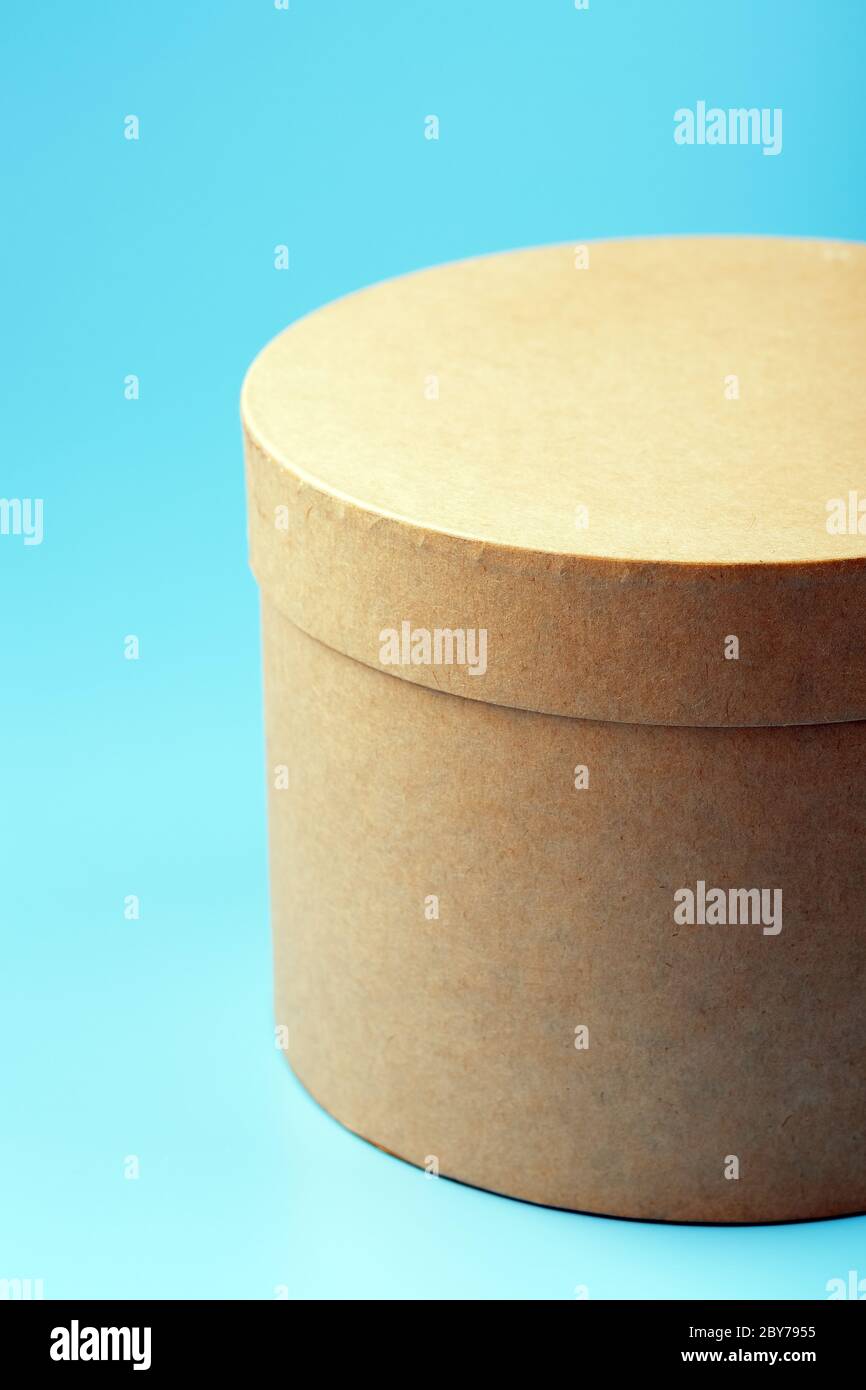 Round cardboard box on a blue background, free space Stock Photo - Alamy