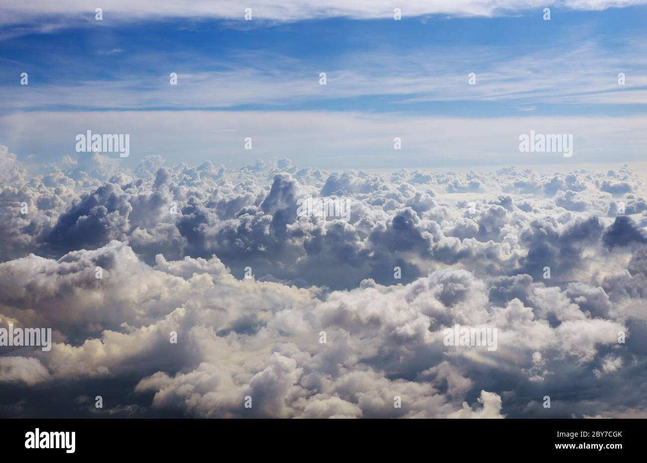 Airplane flying in the clouds clear blue sky under high clouds located ...