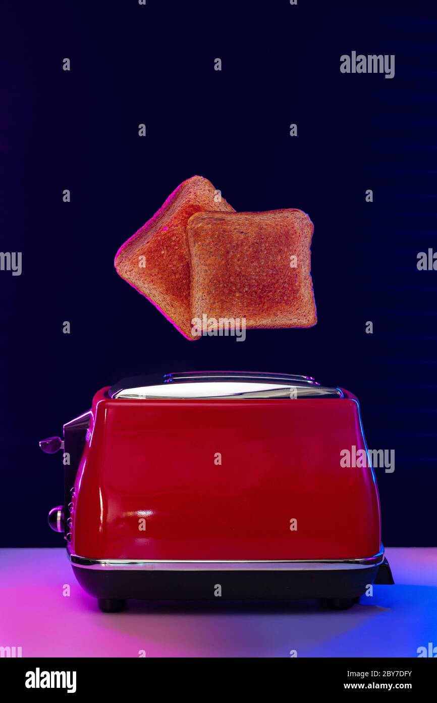 Two toast slices jumping out of toaster in neon light Stock Photo - Alamy