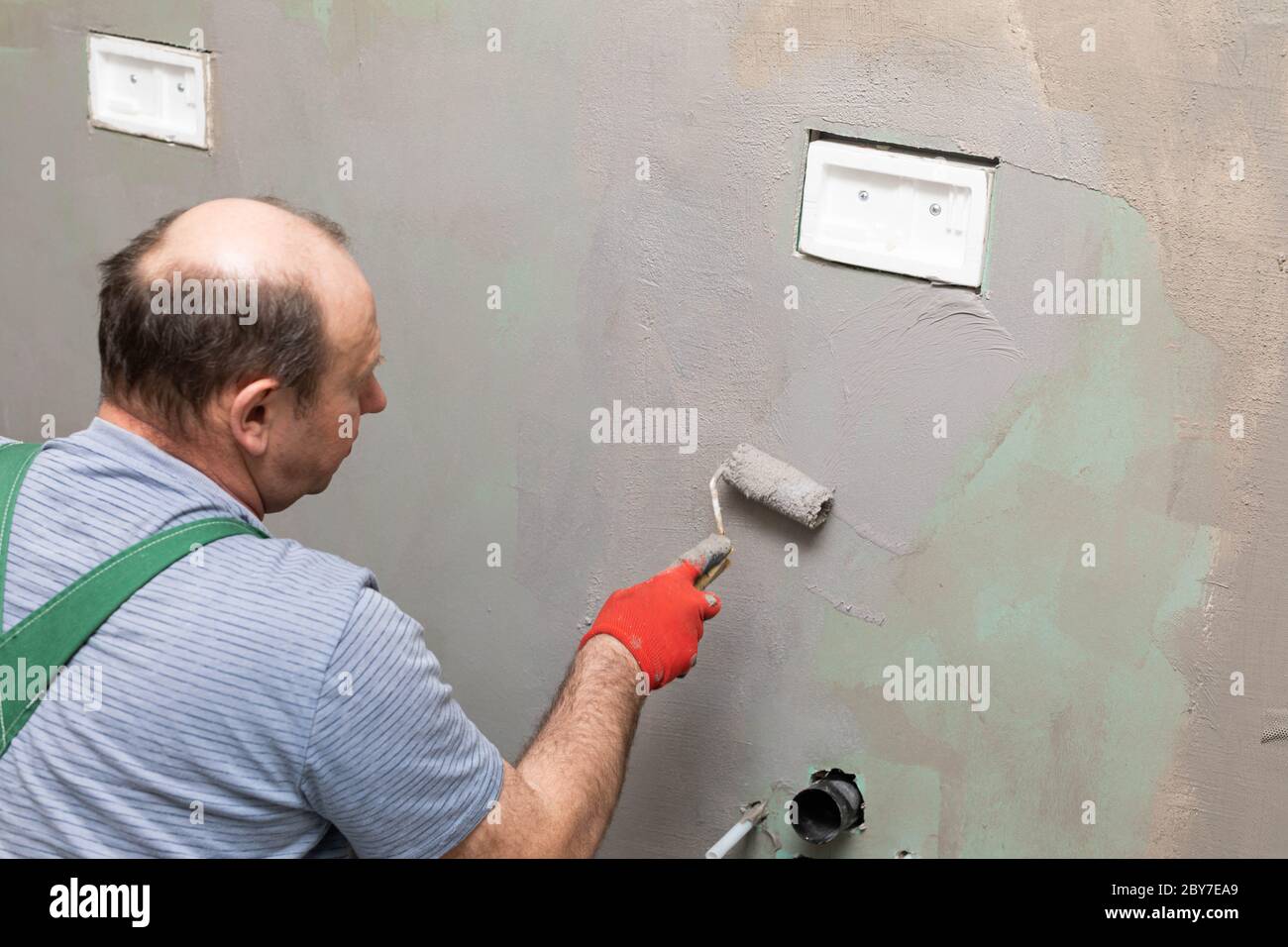 Bathroom renovation. Construction worker. Mineral moisture insulation ...