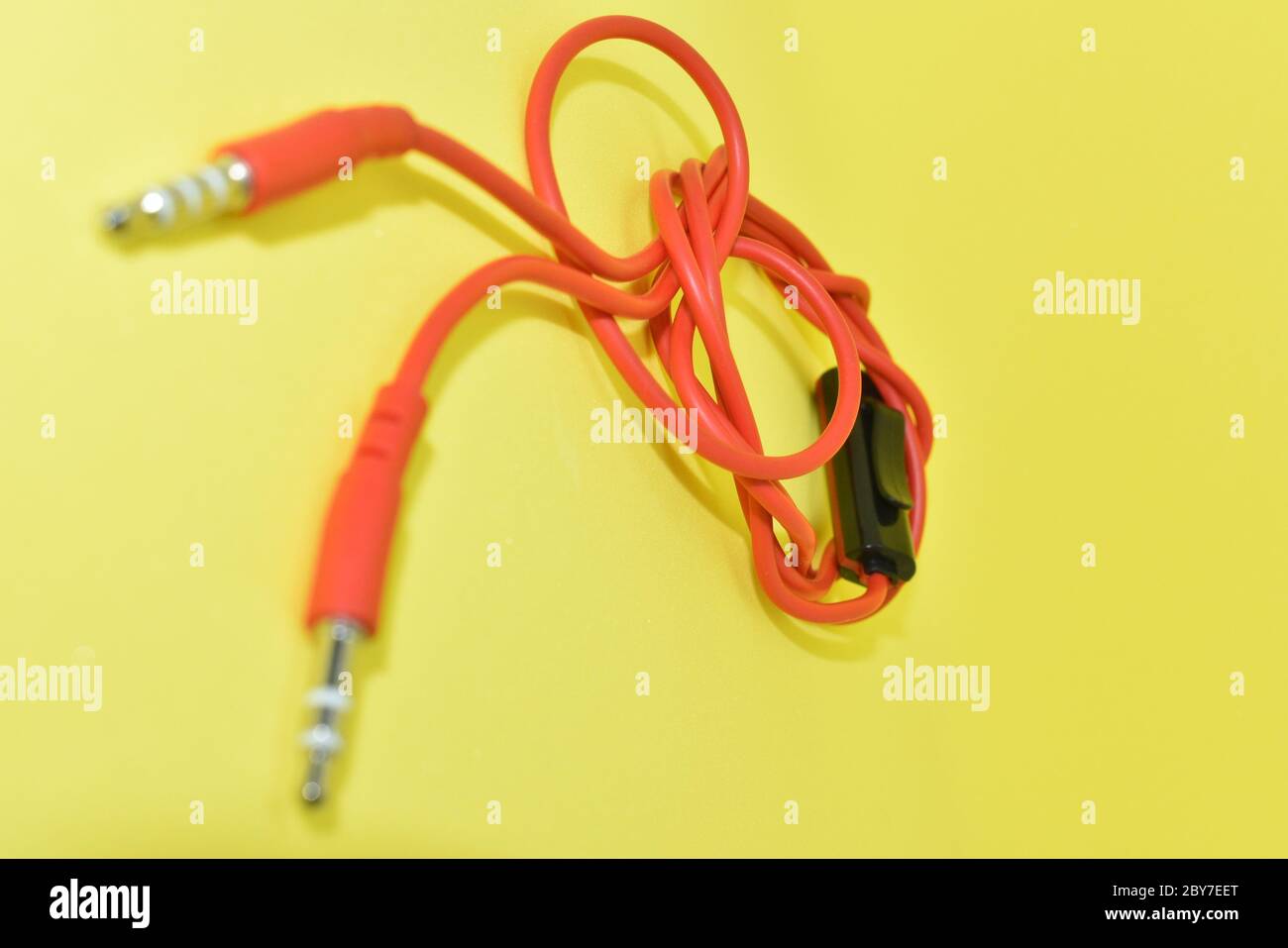 Red color cable in yellow background Stock Photo - Alamy
