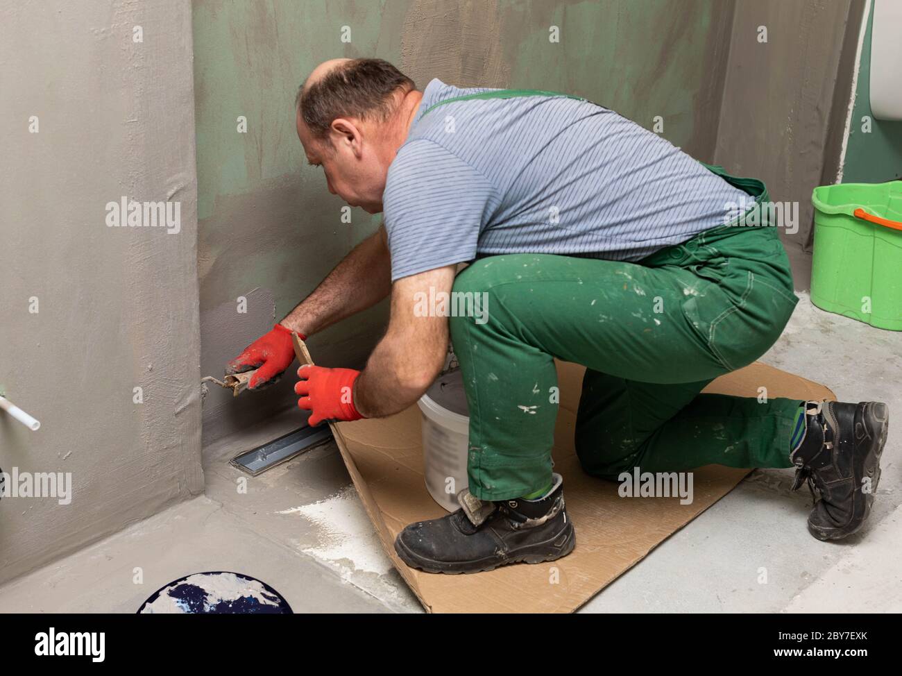Bathroom renovation. Construction worker. Mineral moisture insulation ...