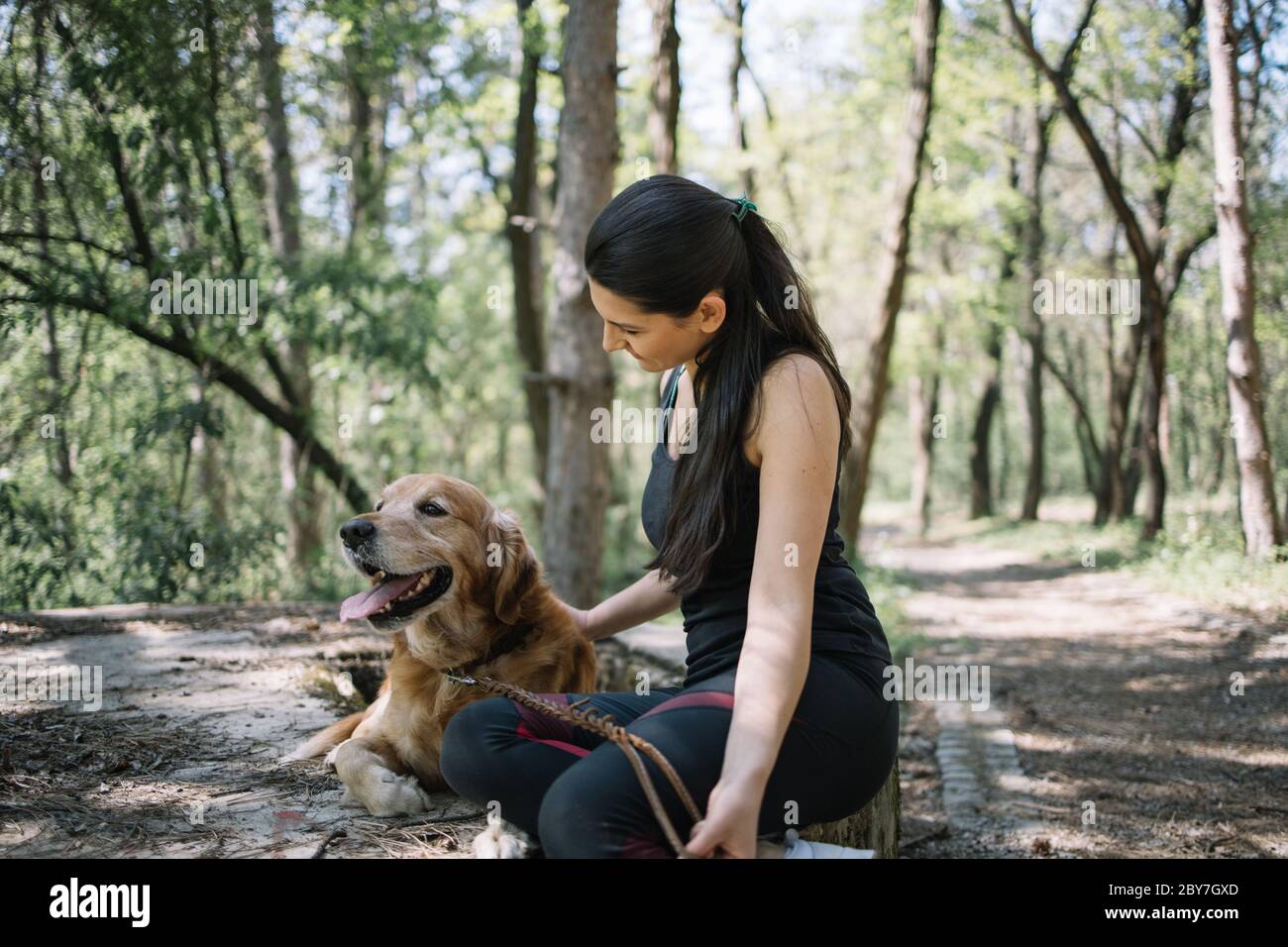 Side view of girl and her dog in forest Stock Photo - Alamy