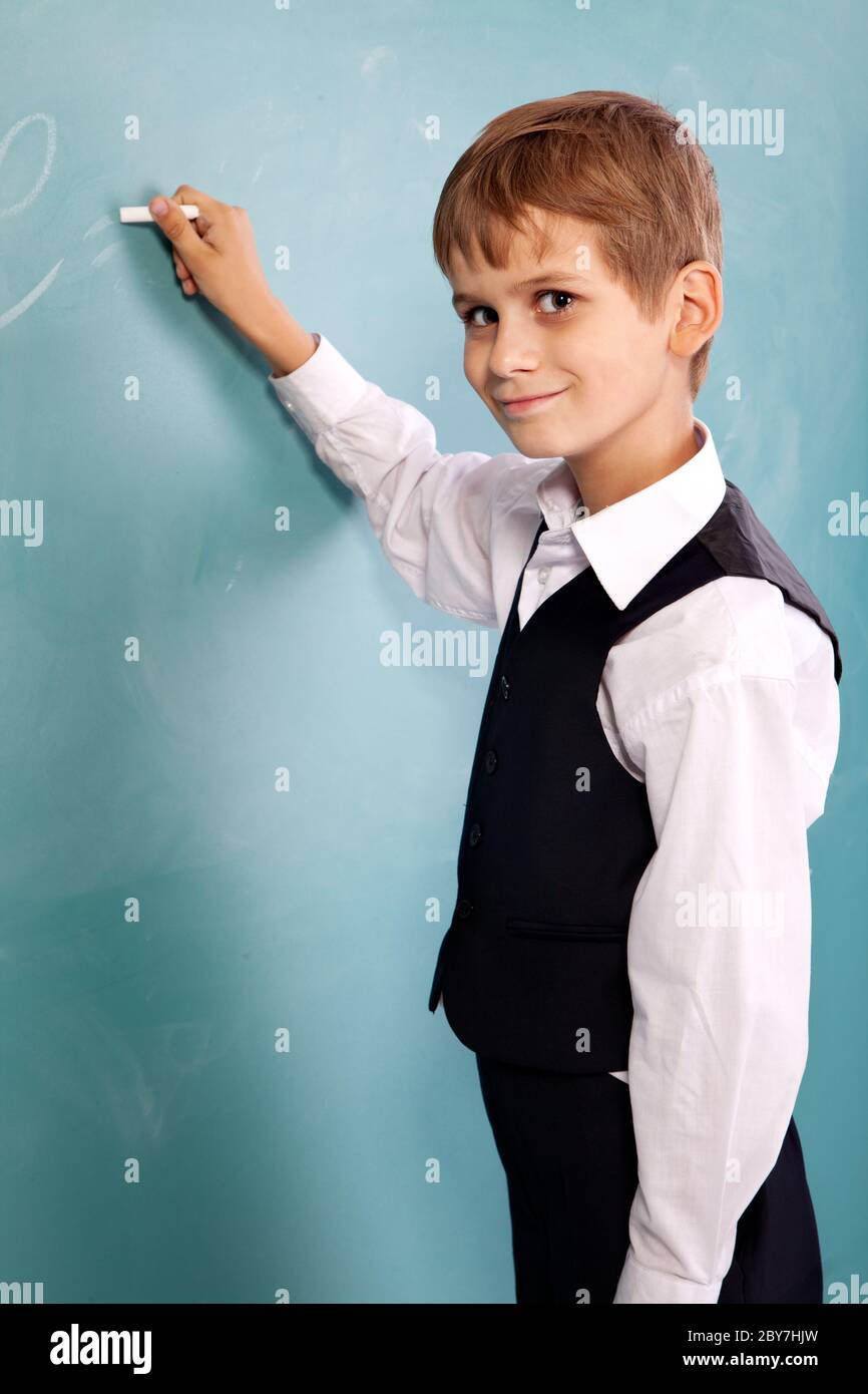 School student writing on blackboard at school Stock Photo - Alamy
