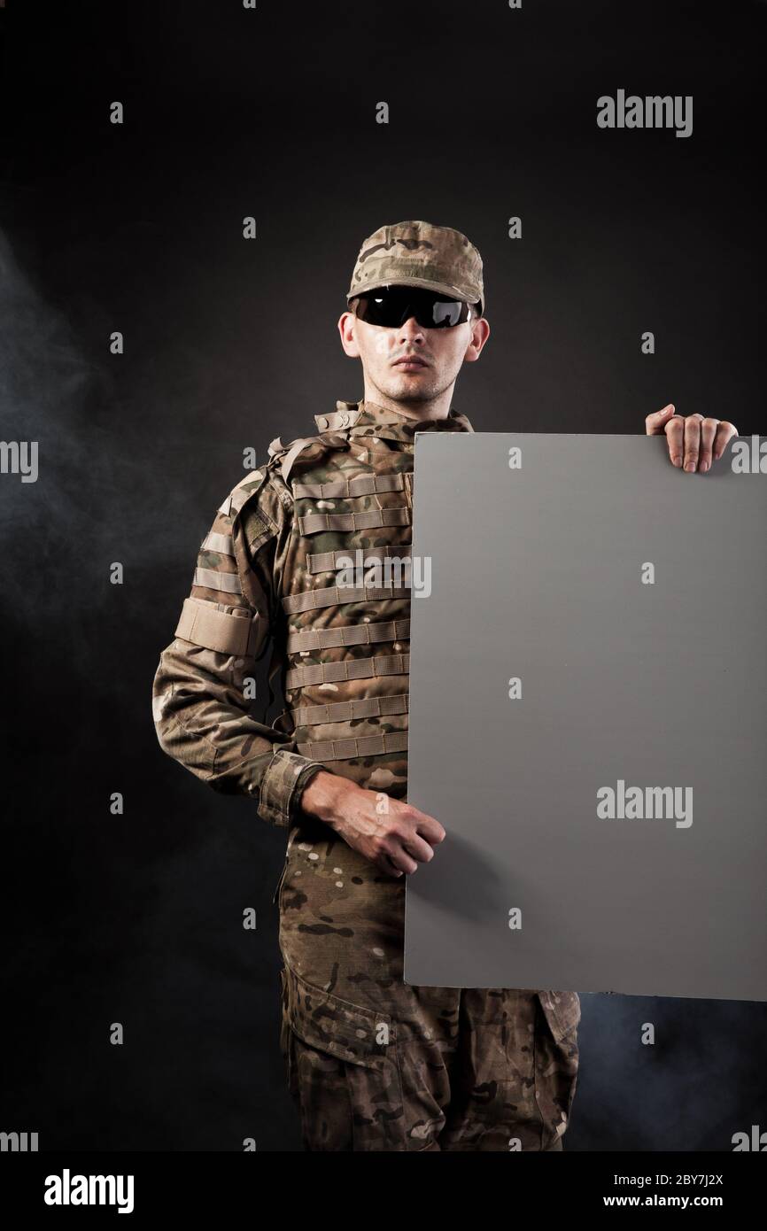 Modern soldier is holding a poster Stock Photo - Alamy