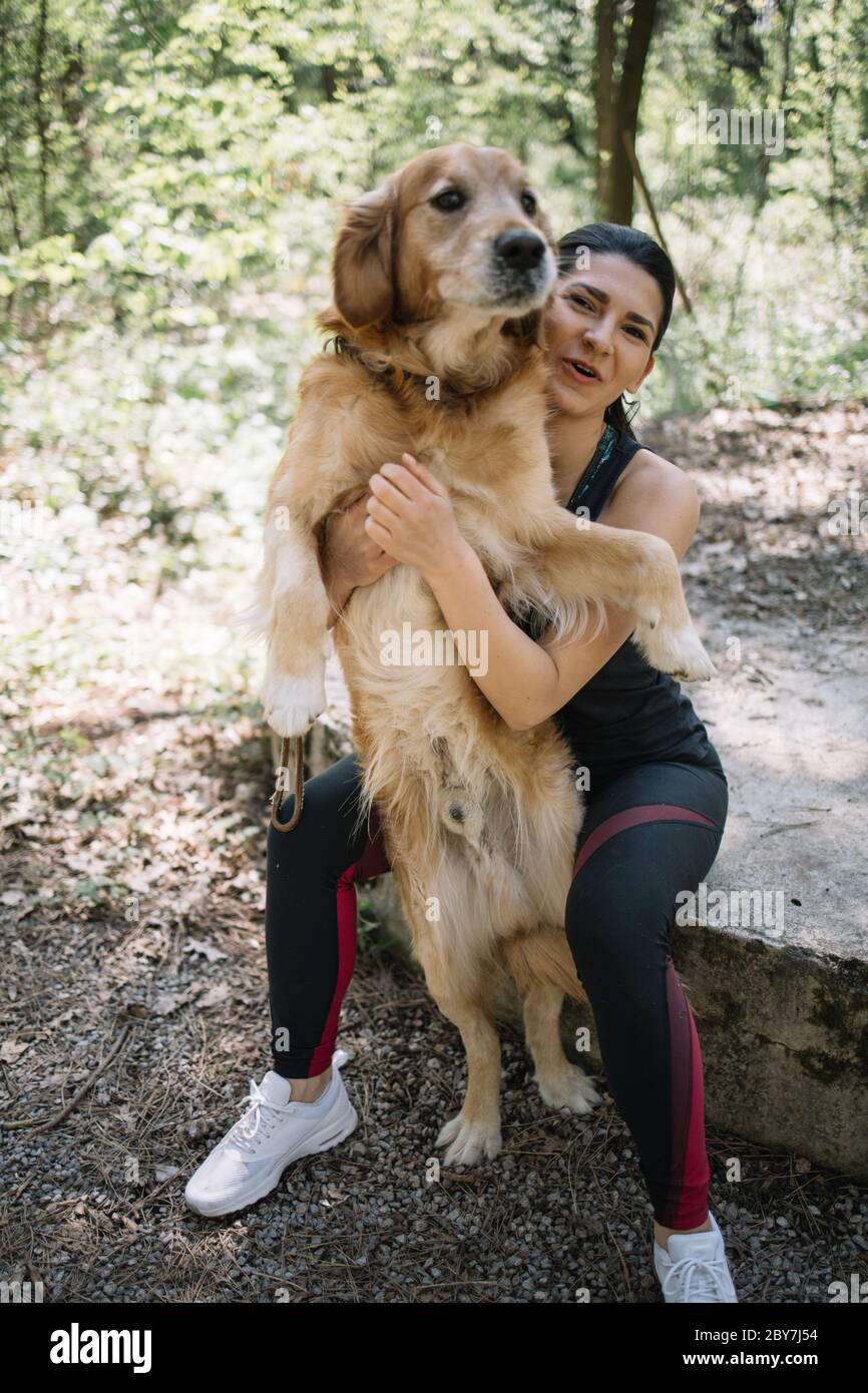 Pretty lady cuddling her dog in nature Stock Photo - Alamy