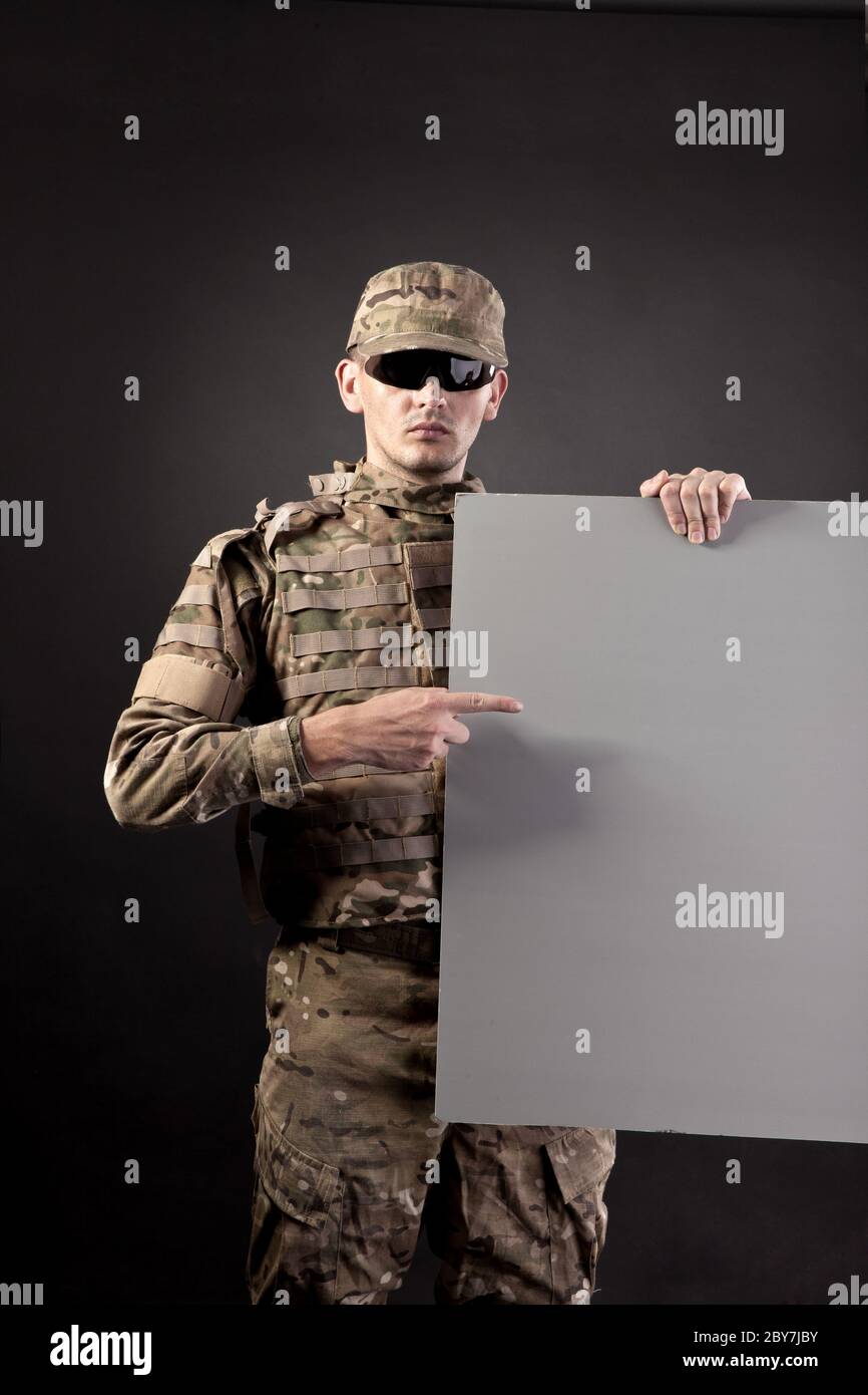 Modern soldier is holding a poster Stock Photo - Alamy