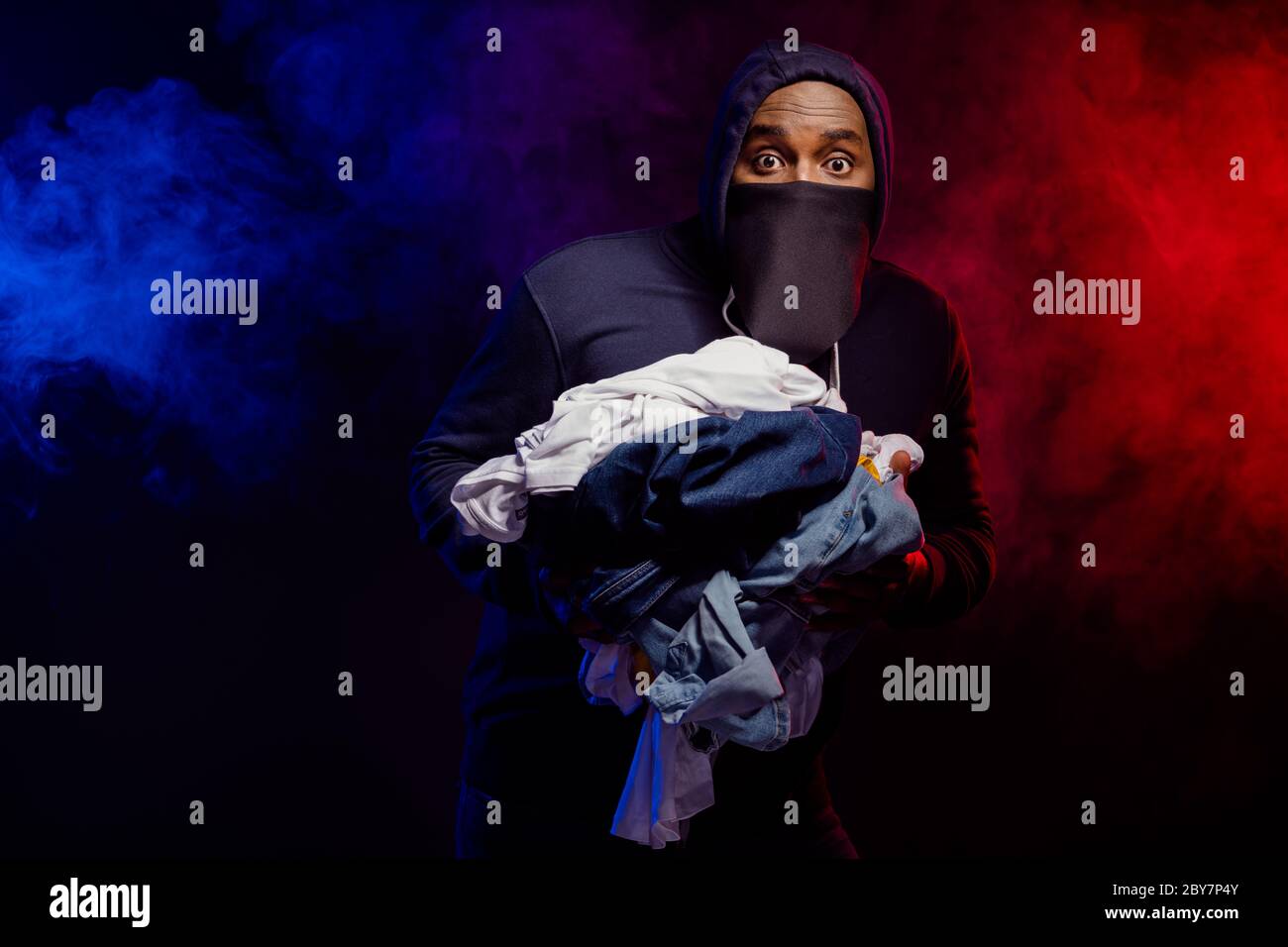 Portrait of scared frightened afro american guy rob boutique shop hold ...