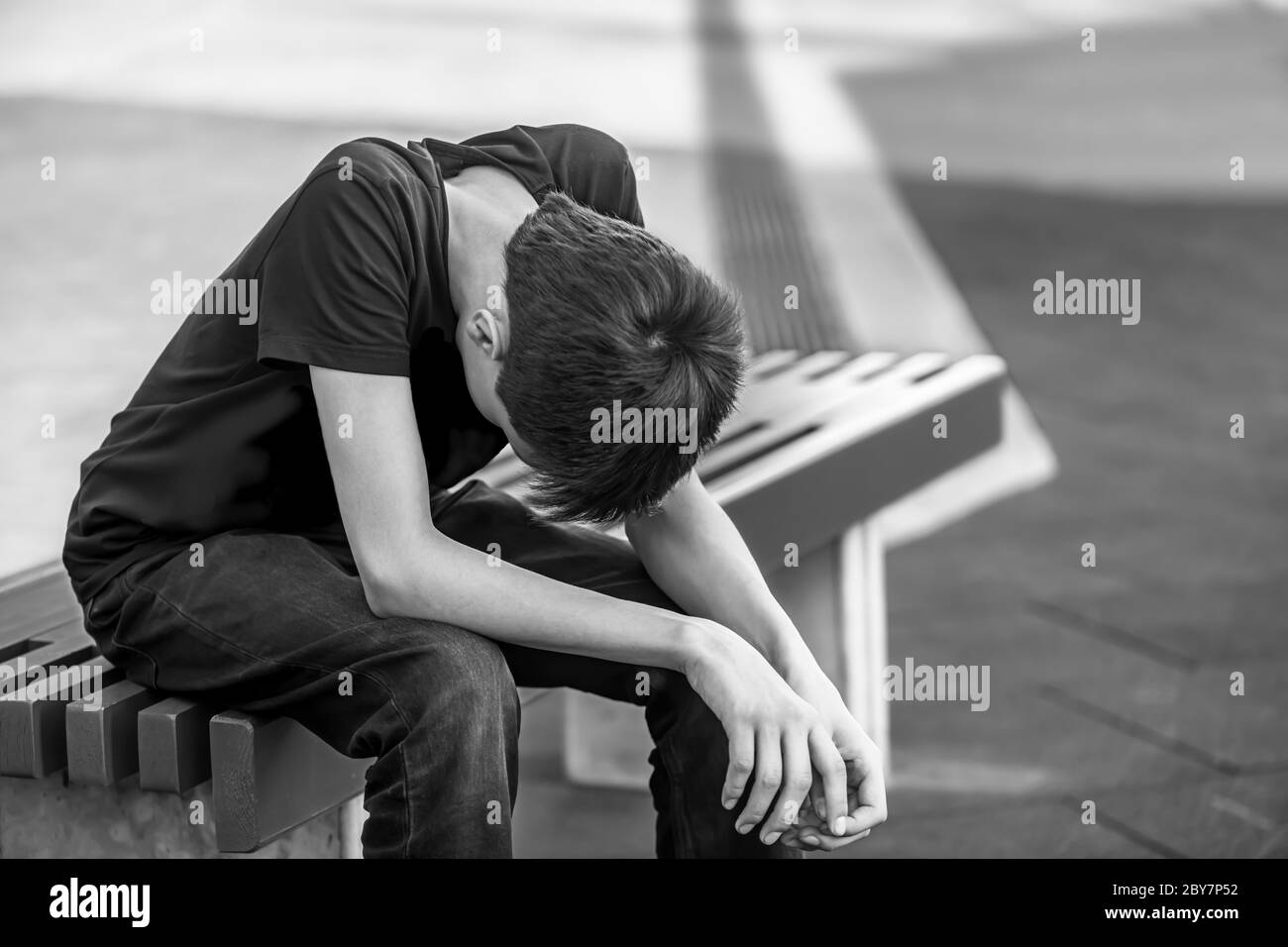 sad teenager male sitting on a bench. black and white Stock Photo - Alamy