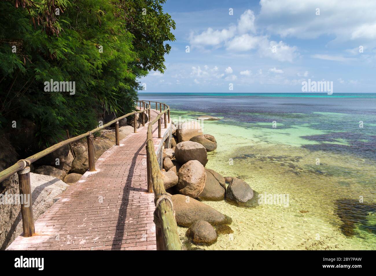 Pathway by the ocean with big stones and green plants Stock Photo - Alamy