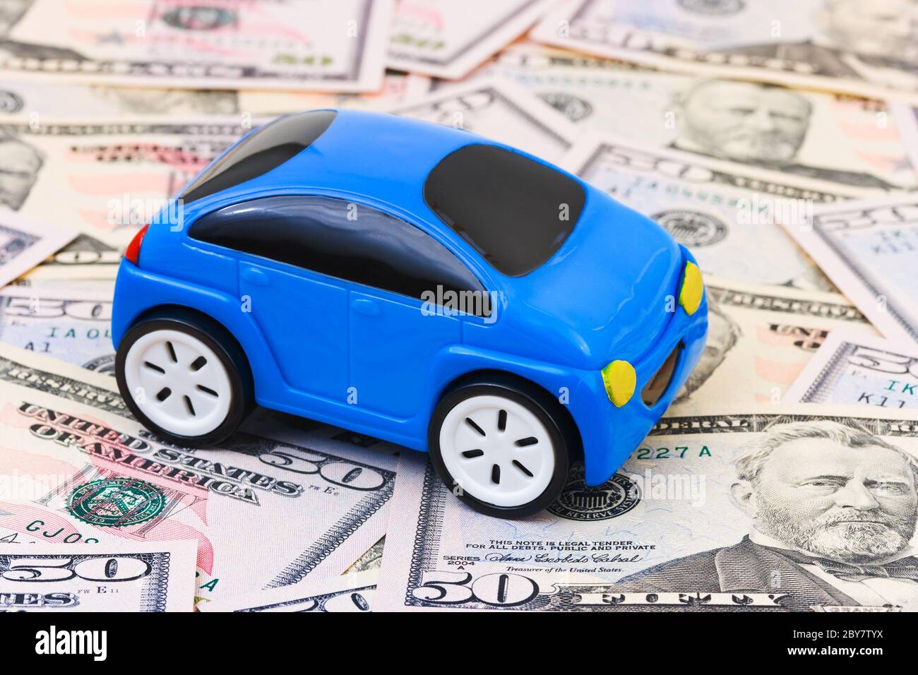 Toy car on money background Stock Photo - Alamy