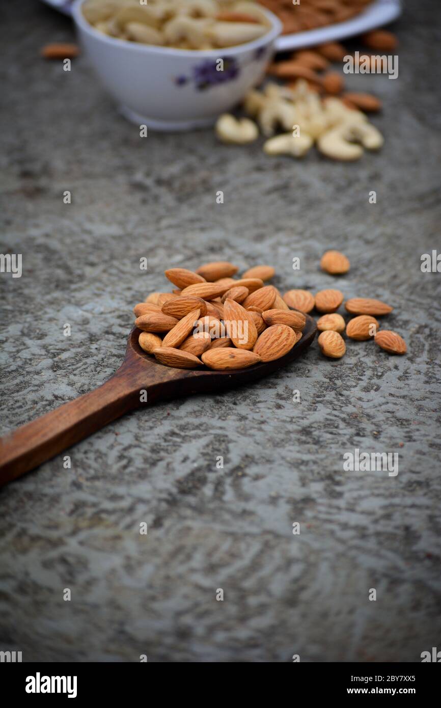 Dried almond nuts in wooden spoon Stock Photo - Alamy