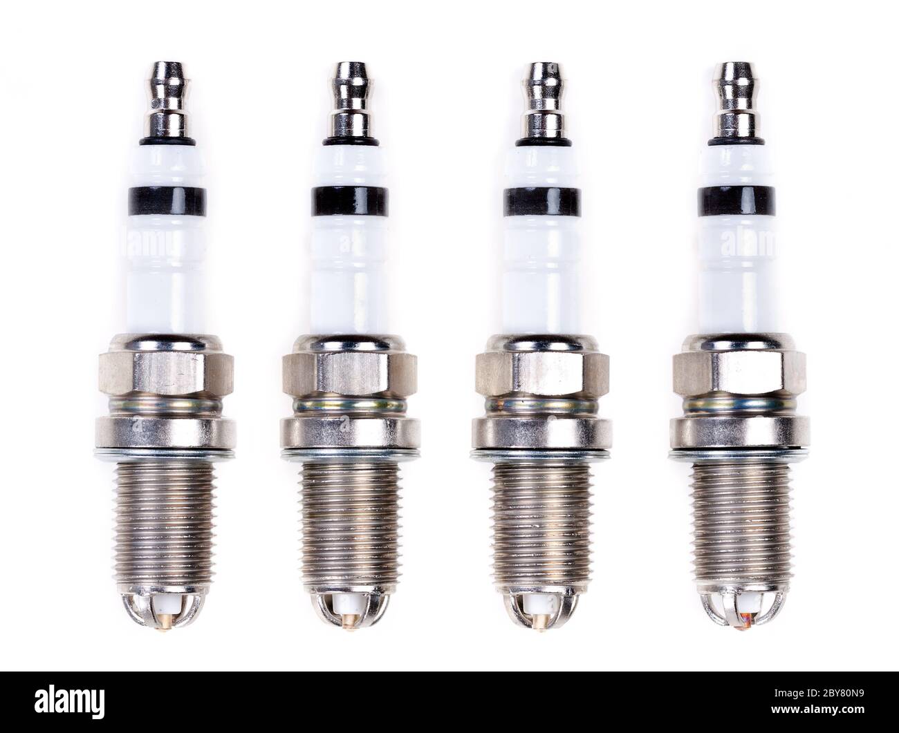 Four spark plugs. Isolated on white Stock Photo - Alamy