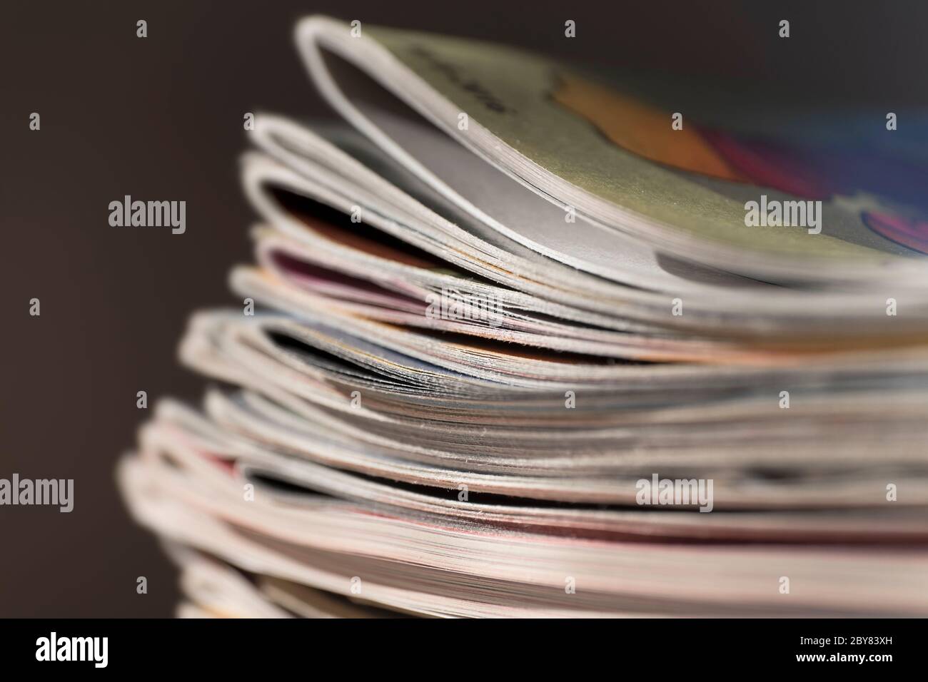 Stack of colored magazines on black background with narrow depth of ...