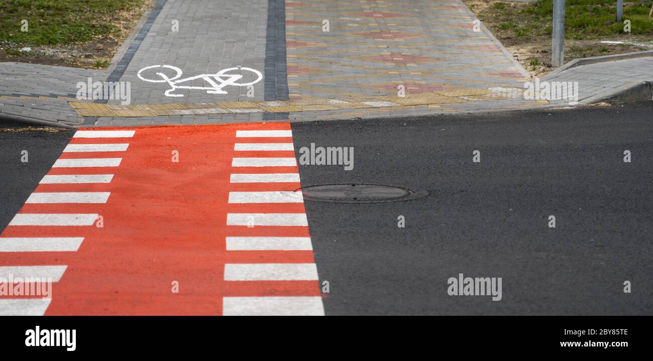 Cycling path with a symbol of bike on a ground through avtomobile road ...