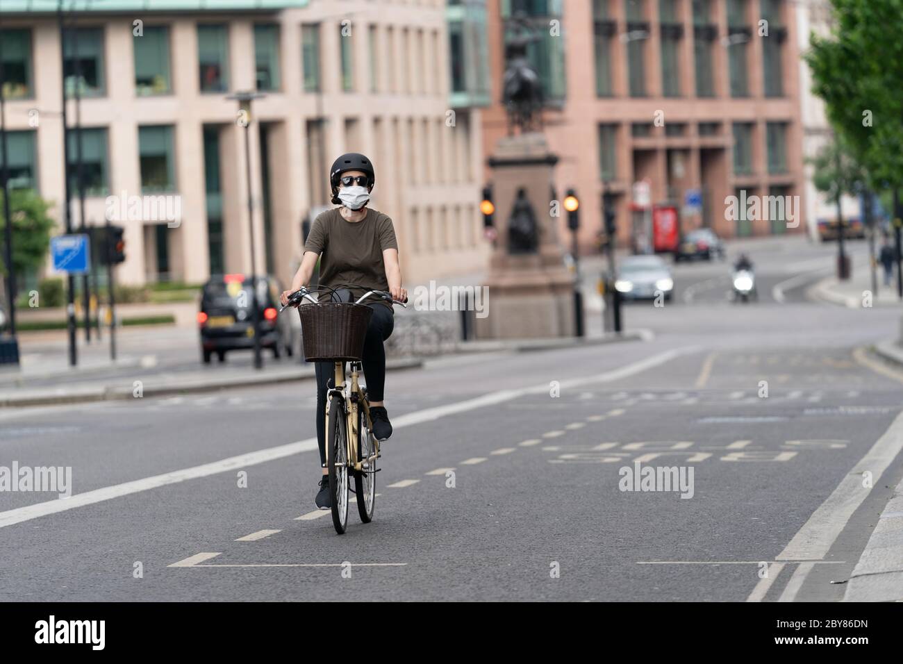 Young woman cyclist in the distance bike riding on a bus lane in Holborn, Central London ...